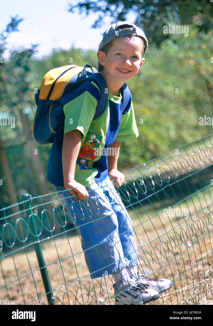 child boy schoolboy smile smiling knapsack cap passage passing barrier ...