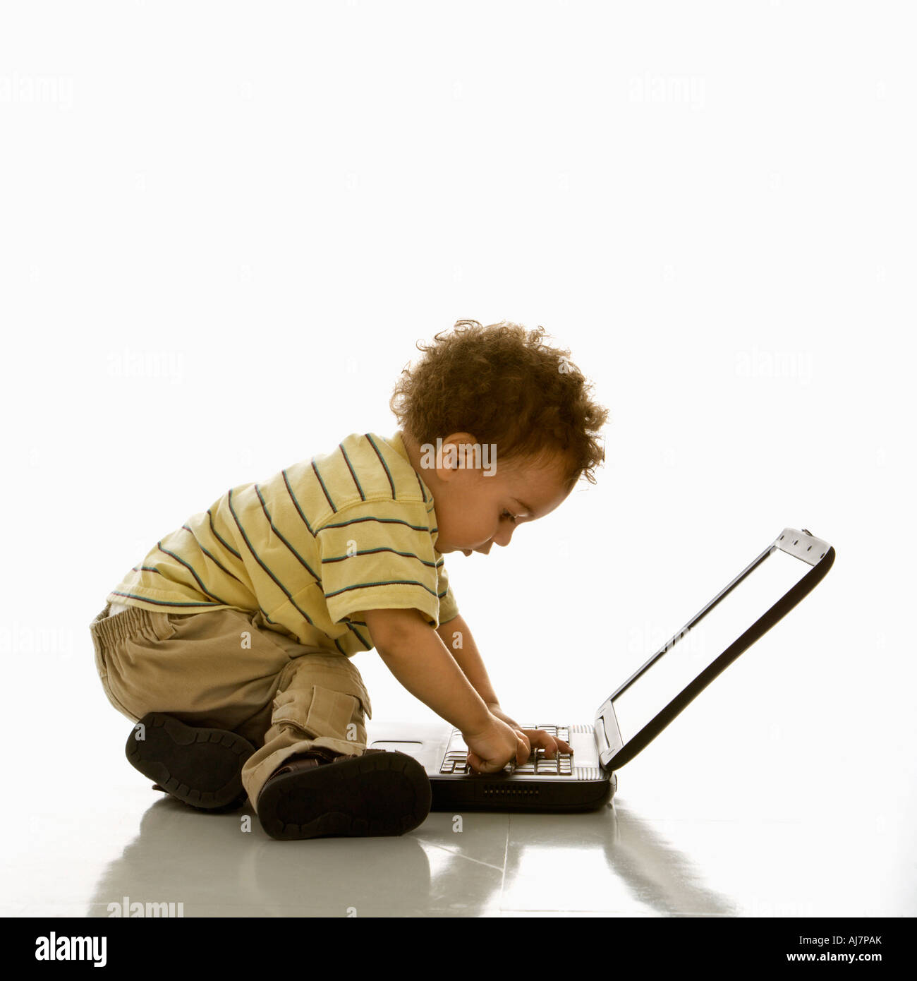 Side view of African American toddler boy using laptop computer Stock ...