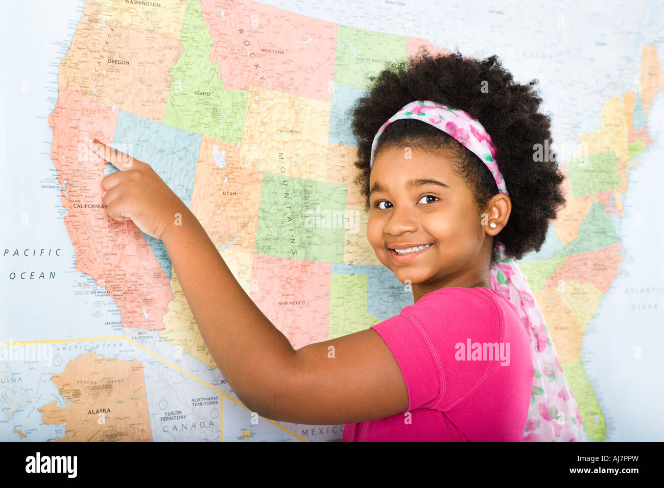 African American girl pointing to map of United States and smiling at ...