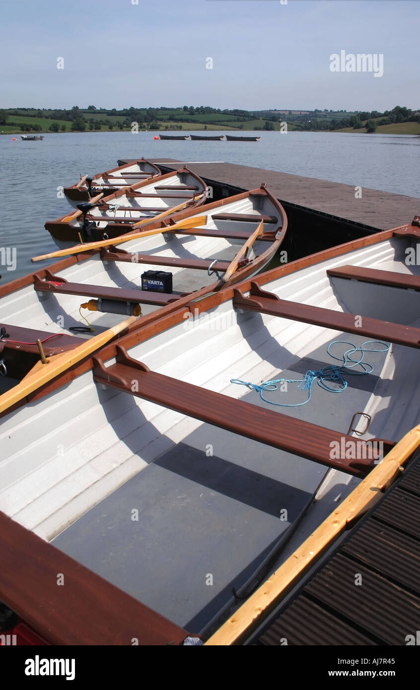 A row of 4 empty rowing boats lined up on the jetty at Corbet Lough ...