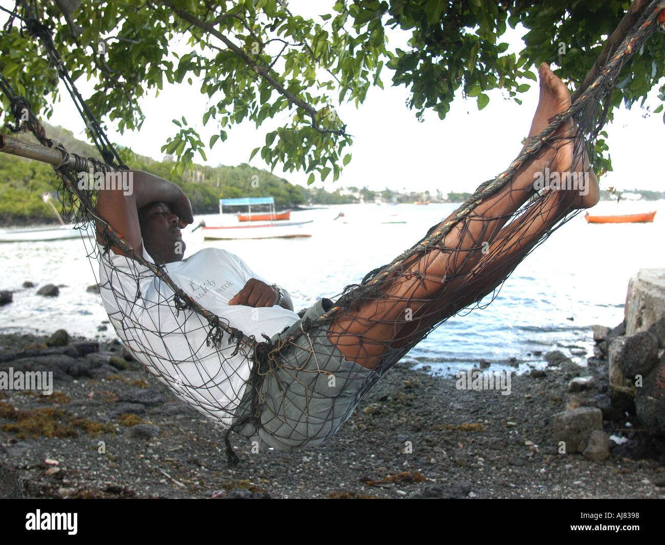 Man lying in hammock at beach, Mauritius Stock Photo - Alamy