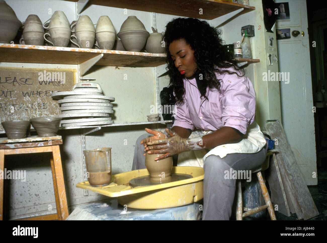 female potter at work throwing a pot on pottery wheel Stock Photo - Alamy