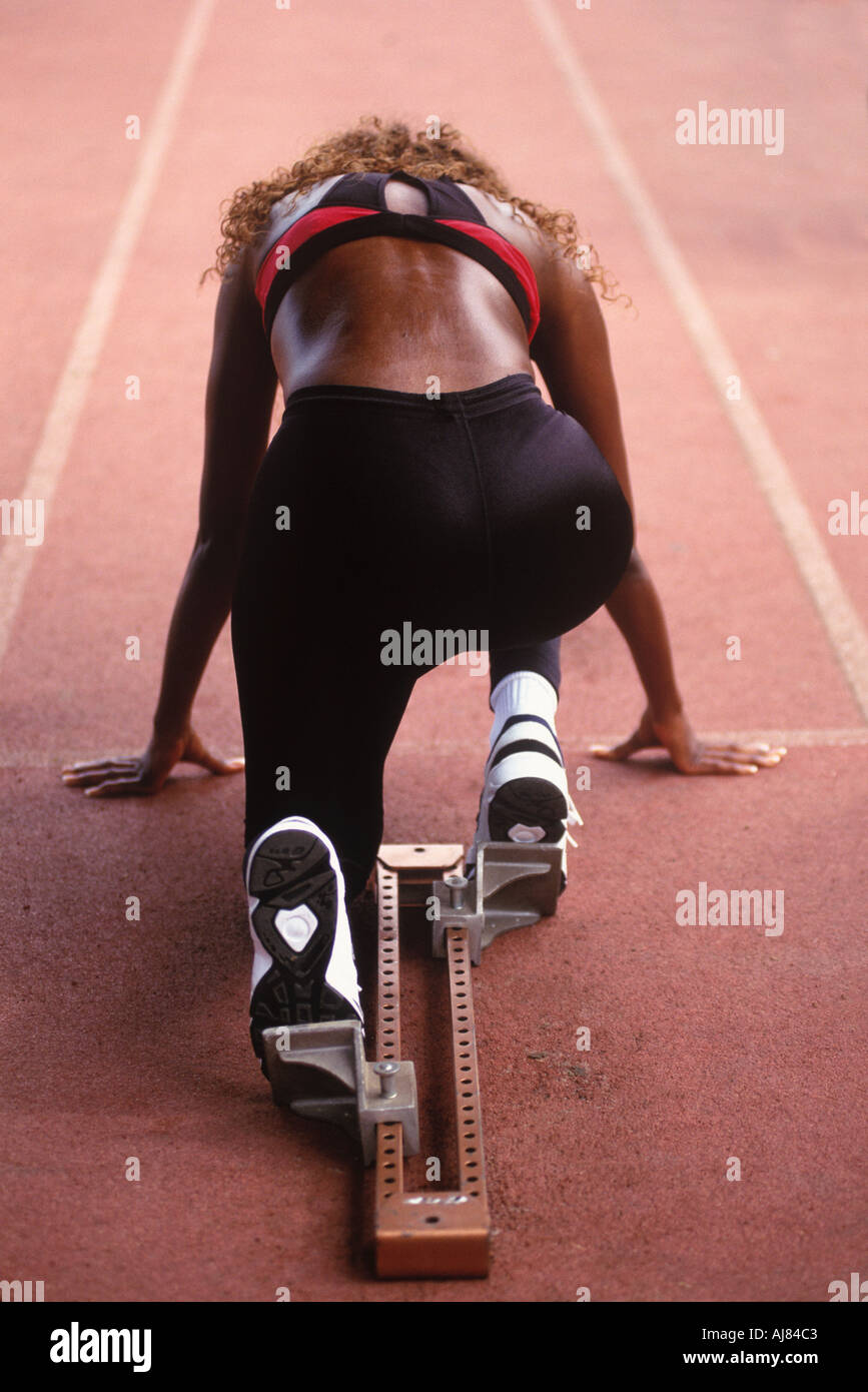 A female black track runner at the starting blocks Stock Photo - Alamy