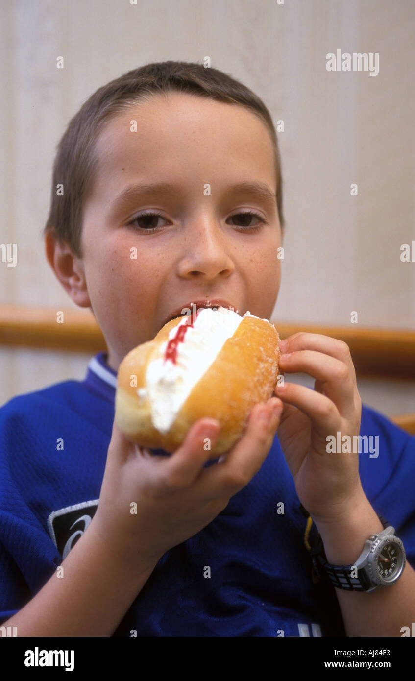 Young child eating cream cake Stock Photo - Alamy