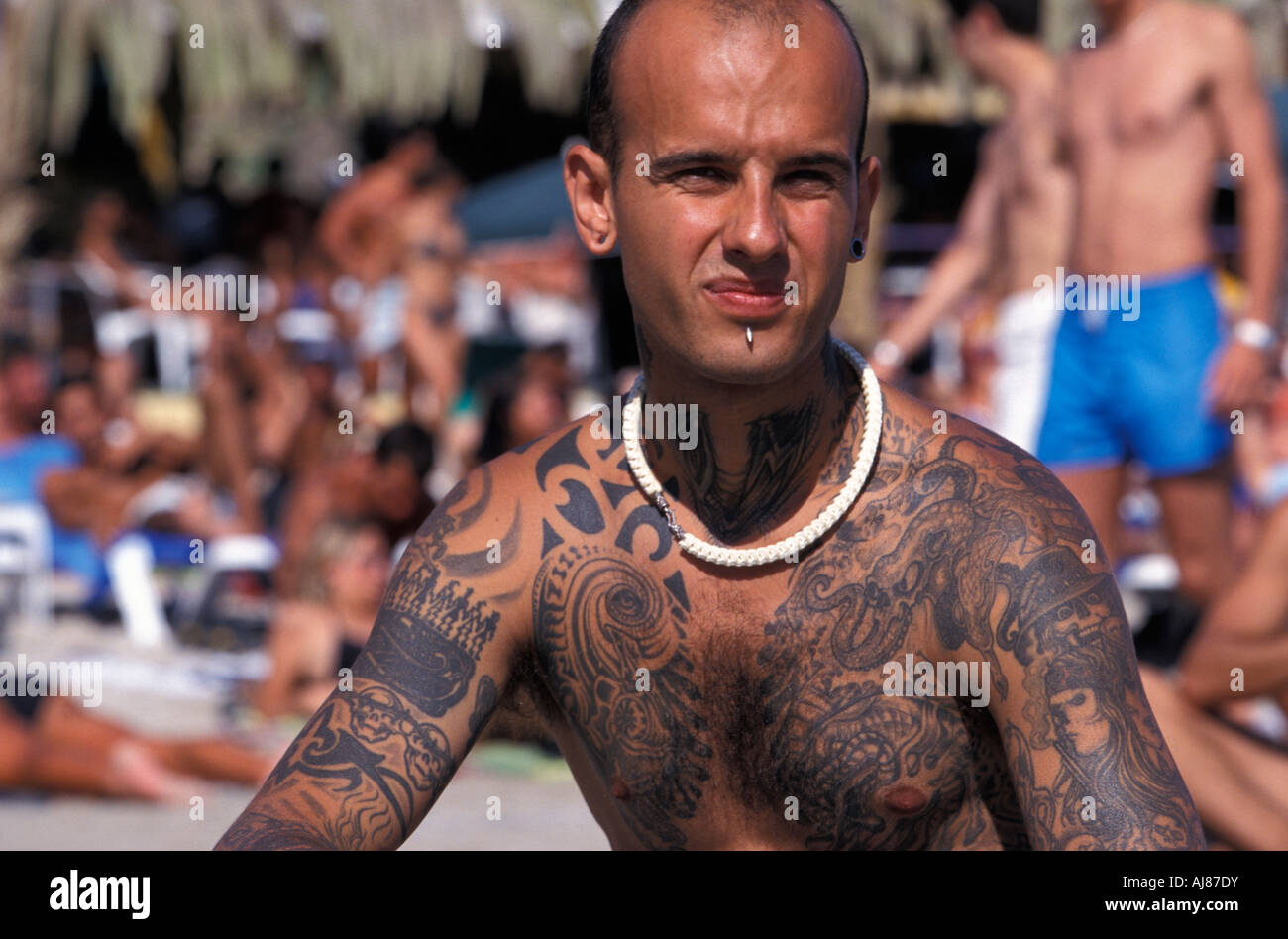 Portrait of a young man with a lot of tattoos at beach Sa Trincha ...