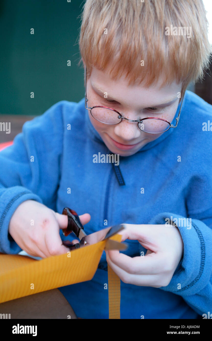 a young boy is working with scissors Stock Photo - Alamy