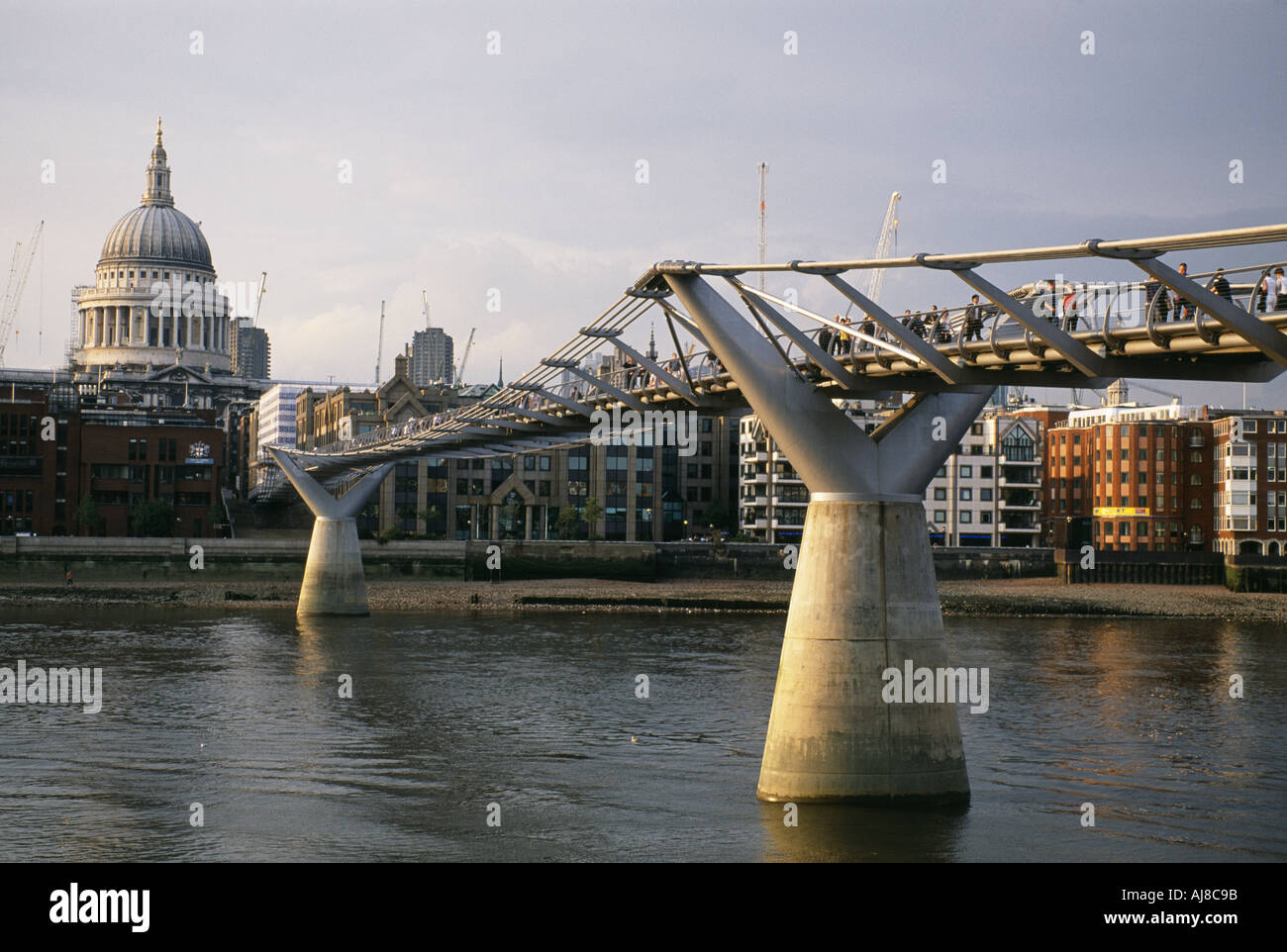 People crossing the Millennium Bridge at designed by Norman Foster ...