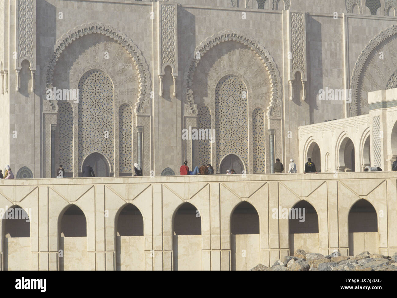 Several Muslims standing on the sea defence wall before a section of ...