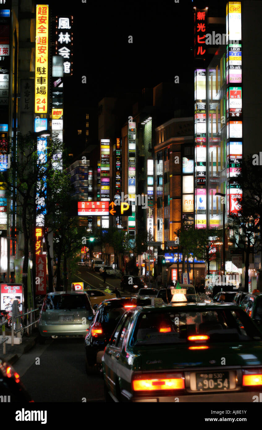 Shinjuku side street at night with traffic and big lit signs Stock ...