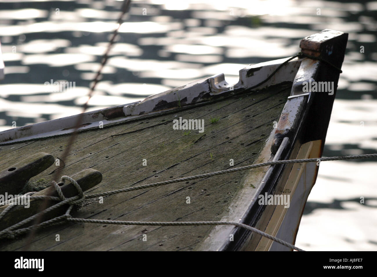 Boat in harbour with blurred sea and ropes Stock Photo - Alamy