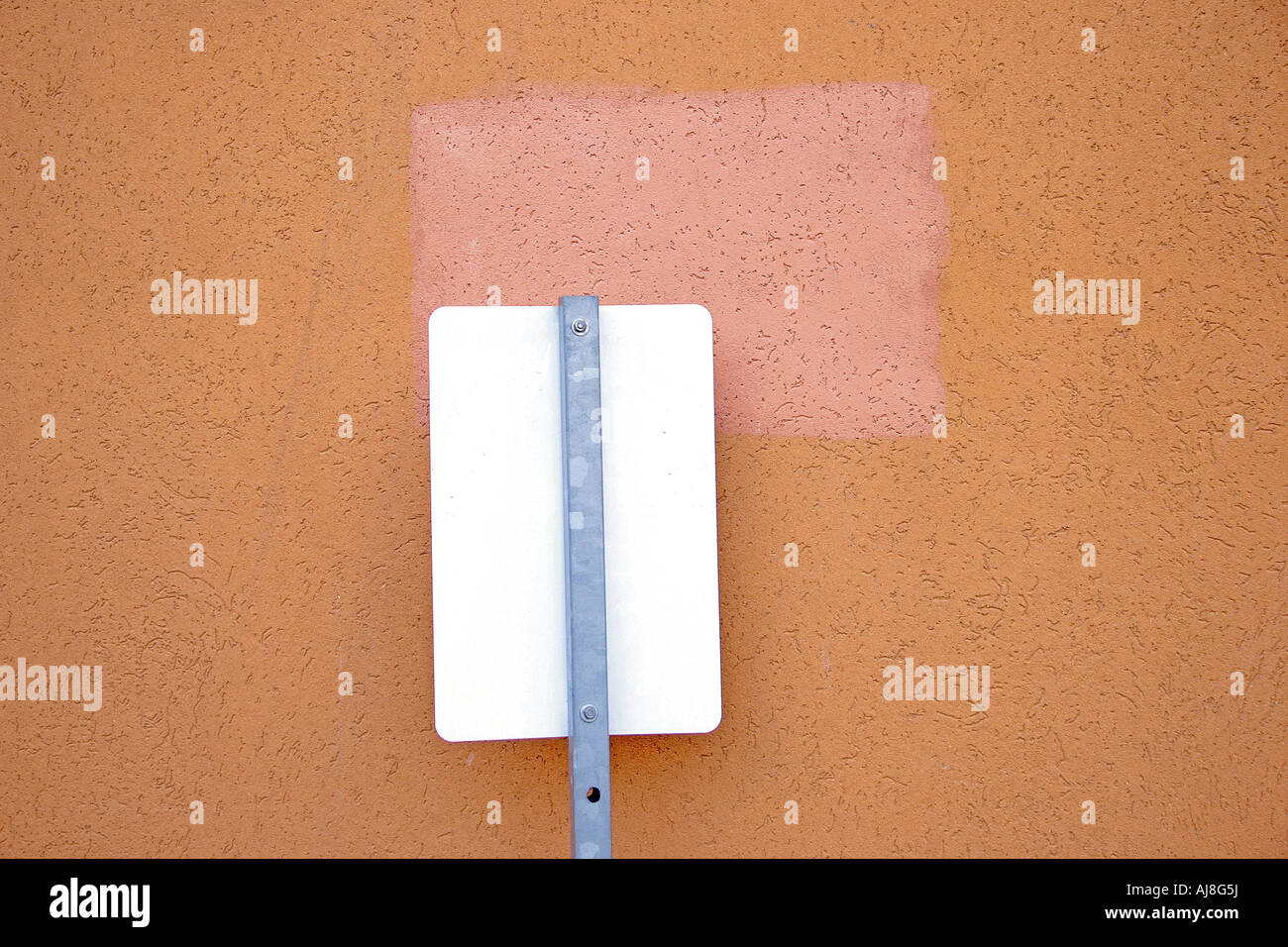 Sign facing orange wall Stock Photo - Alamy