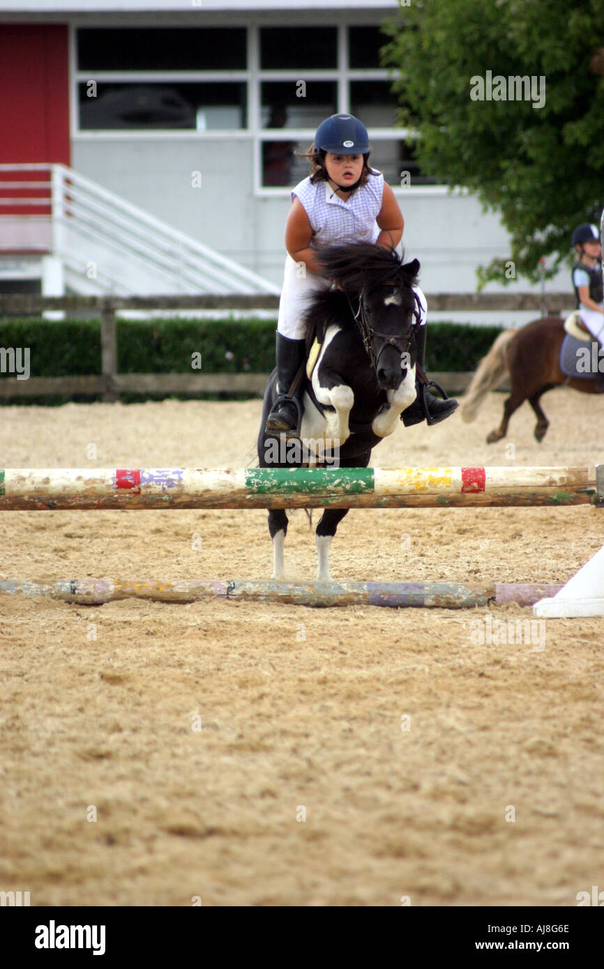 Chubby young girl going over a jump on her pony at the Normandy Horse ...
