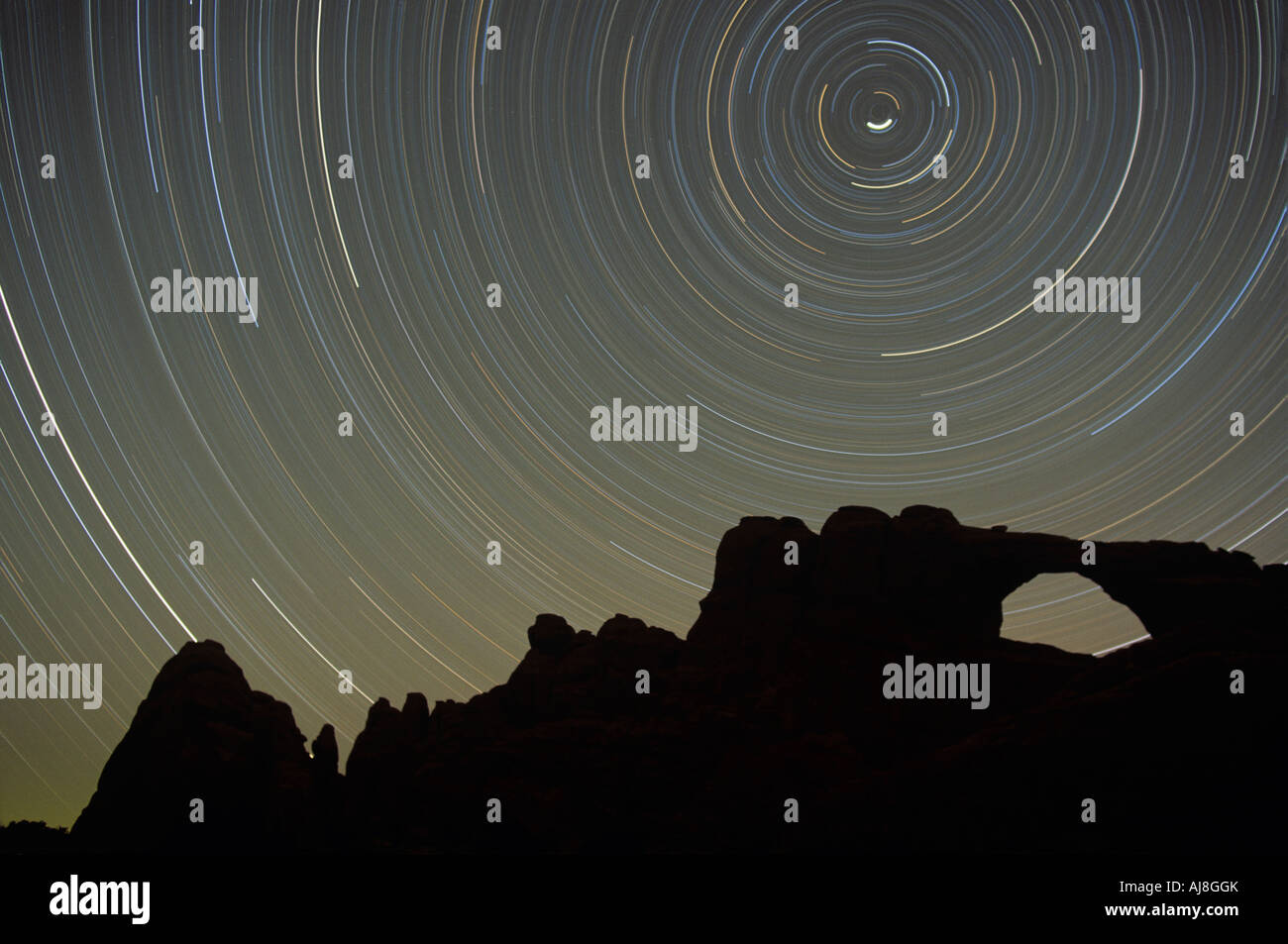 USA Utah Arches National Park Stars circle above sandstone arch during ...