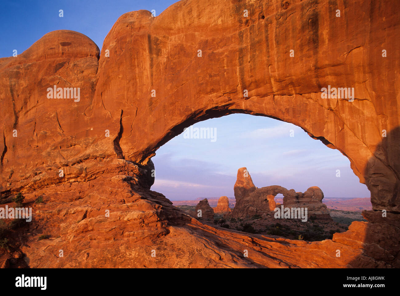 USA Utah Arches National Park Double Arch frames Turret Arch at sunrise ...