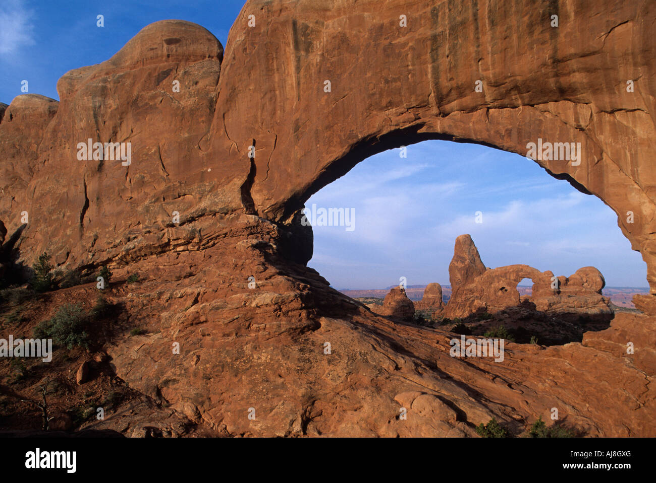 USA Utah Arches National Park Double Arch frames Turret Arch at sunrise ...