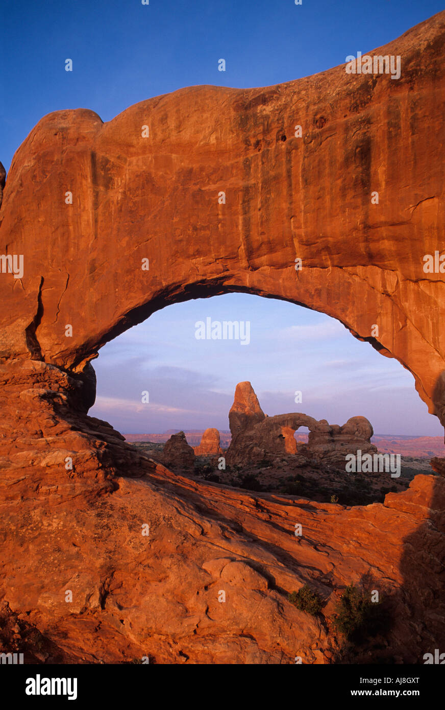 USA Utah Arches National Park Double Arch frames Turret Arch at sunrise ...