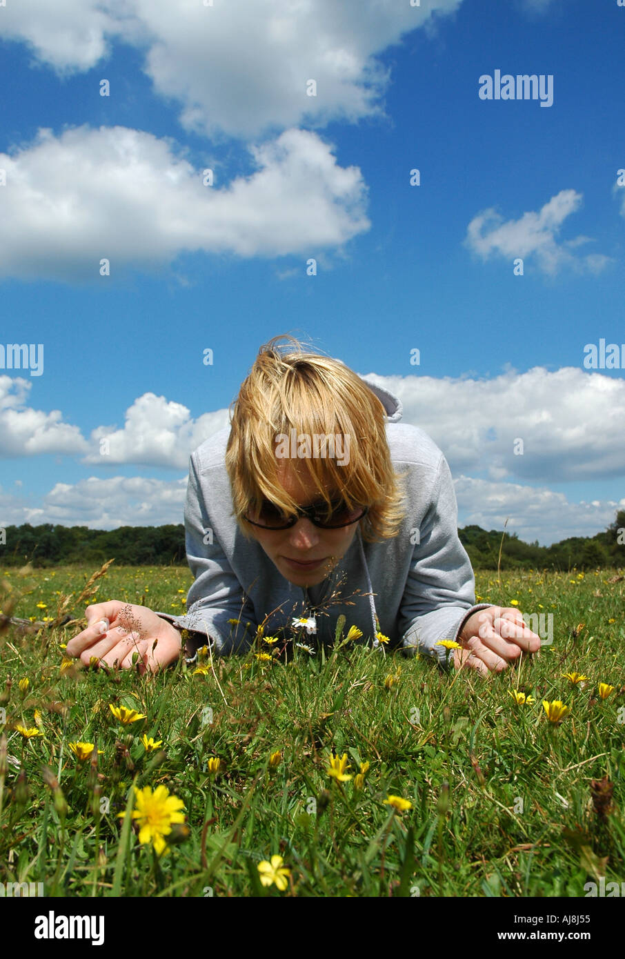 Girl laying on ground smelling flowers Stock Photo - Alamy