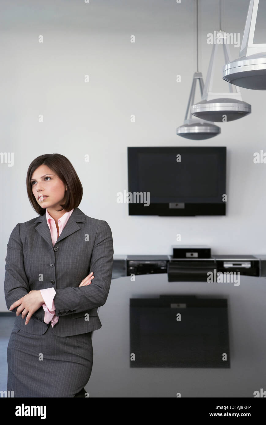 Business woman leaning against table in conference room Stock Photo - Alamy