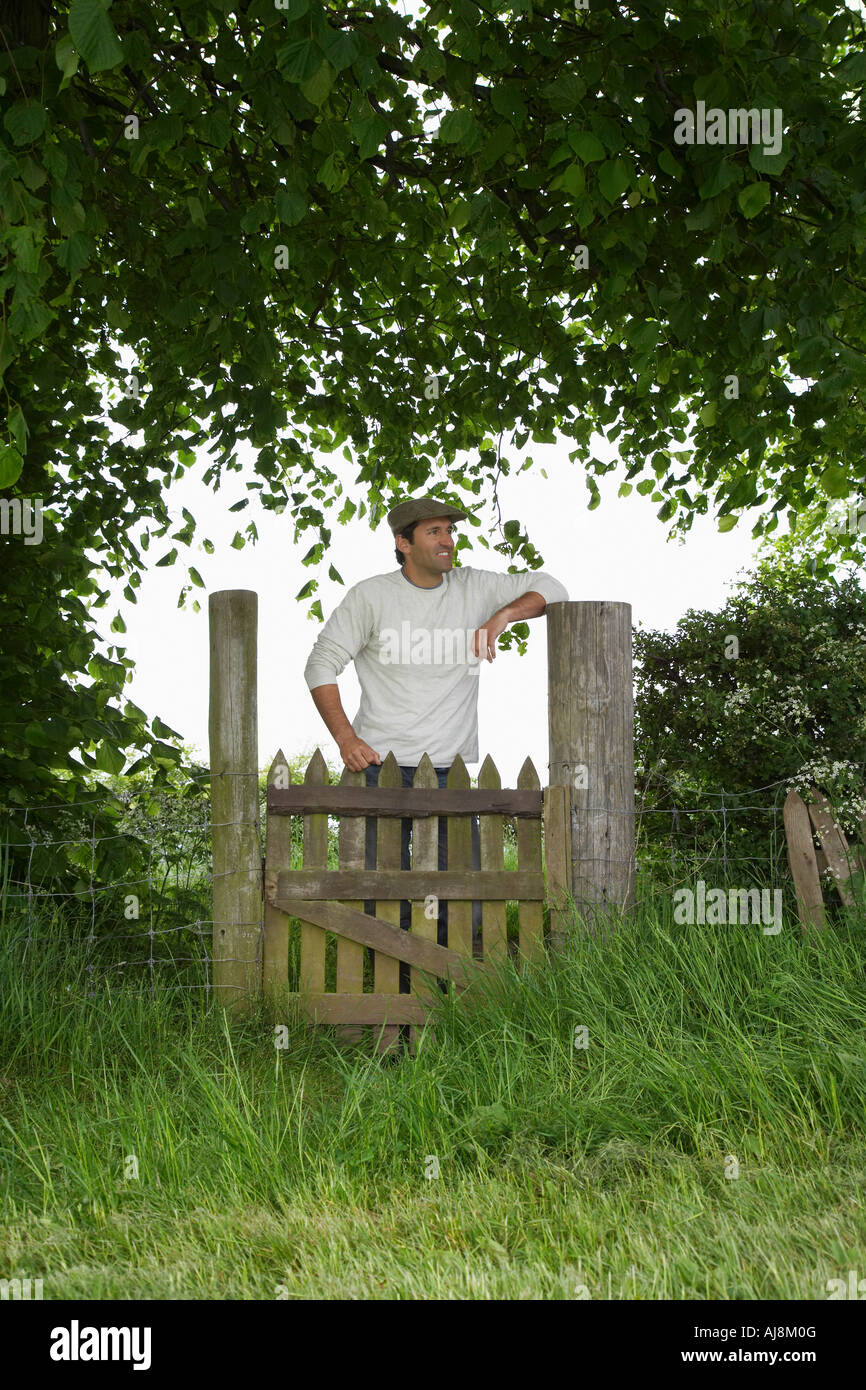 Man standing at gate in countryside Stock Photo - Alamy