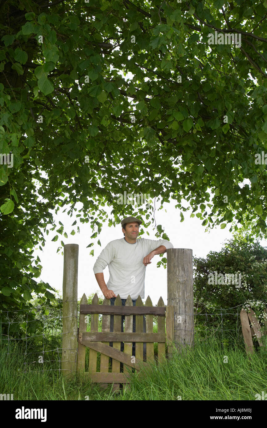 Man standing at gate in countryside Stock Photo - Alamy