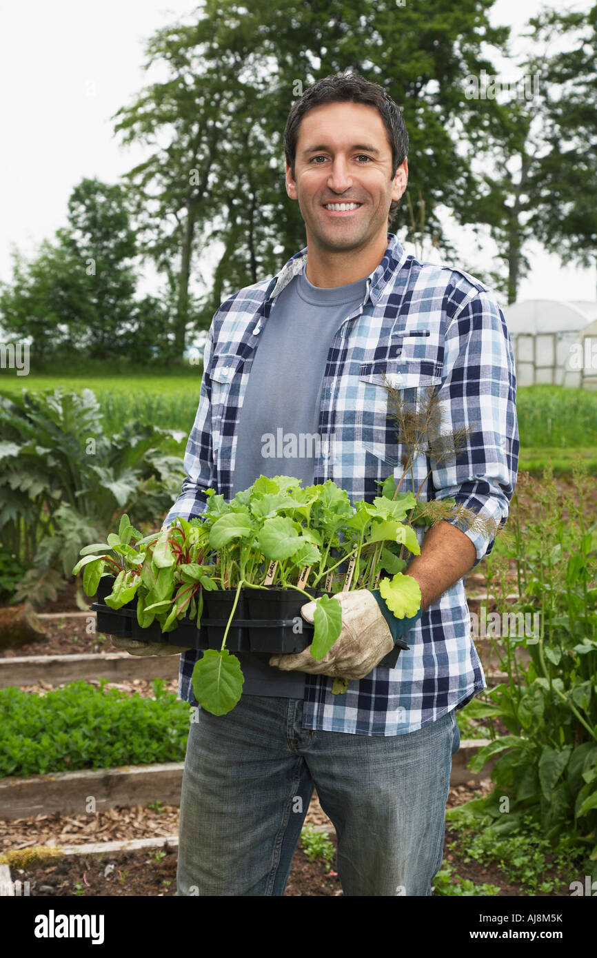 Man carrying plants in field, portrait Stock Photo - Alamy