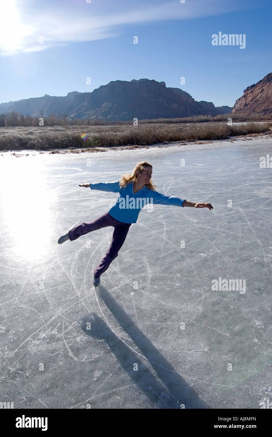 Woman ice-skating on pond, Moab Stock Photo - Alamy