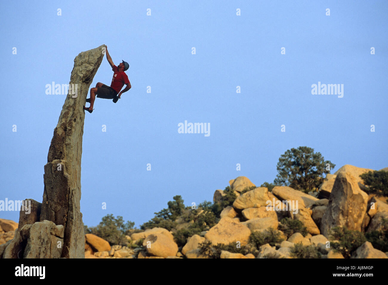 Man solo climbing rock spire Stock Photo - Alamy