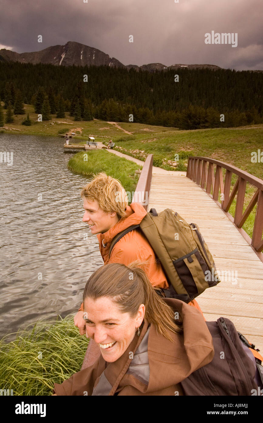 Hikers on bridge look over water Stock Photo - Alamy