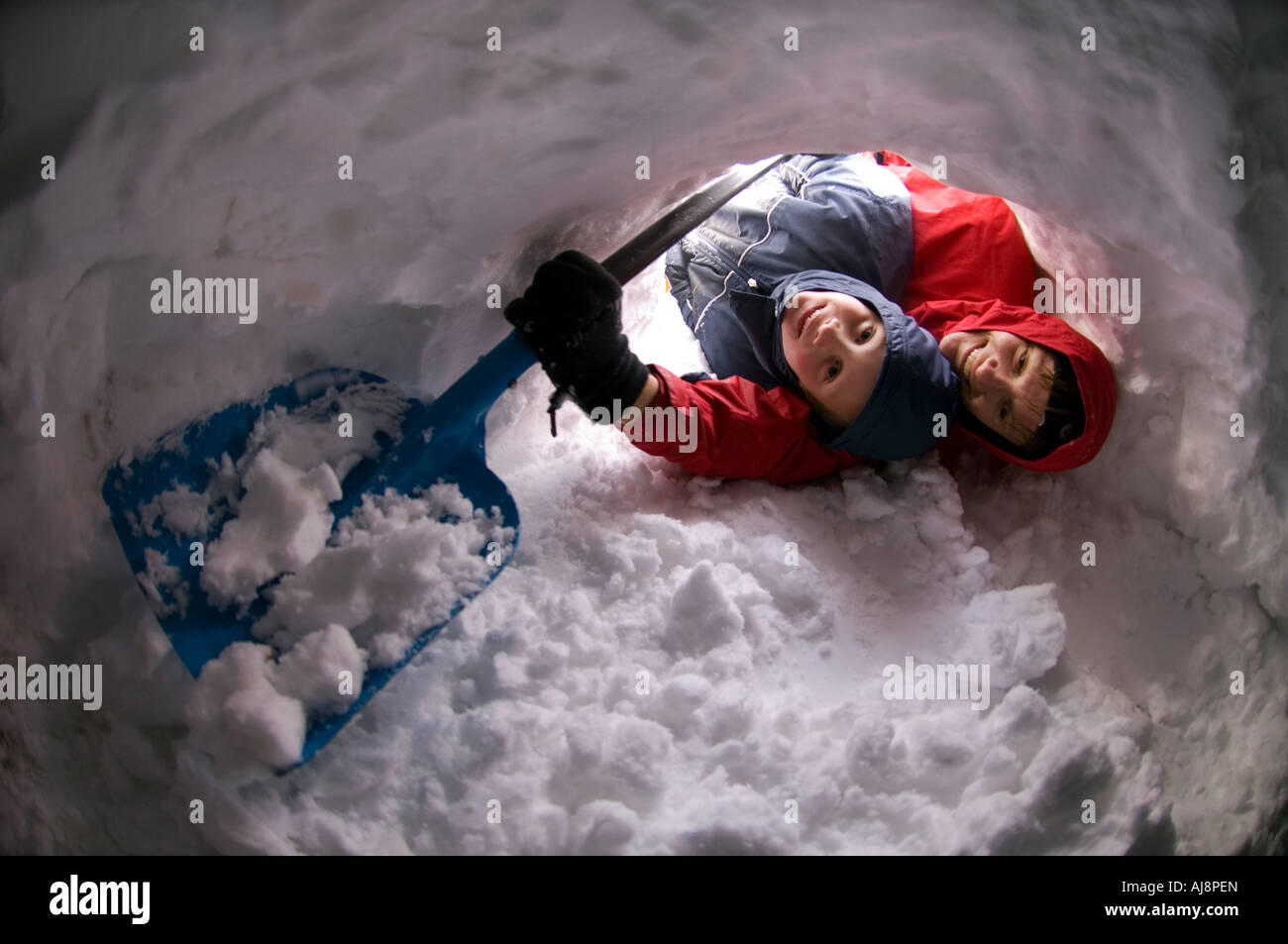Mother and son dig a snow cave Stock Photo - Alamy