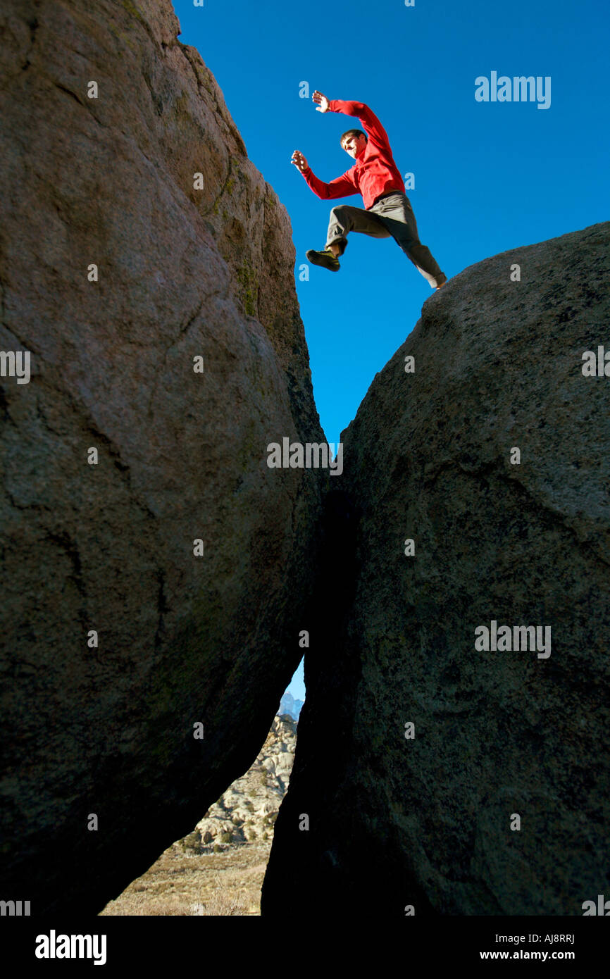 Man jumping across boulders Stock Photo - Alamy