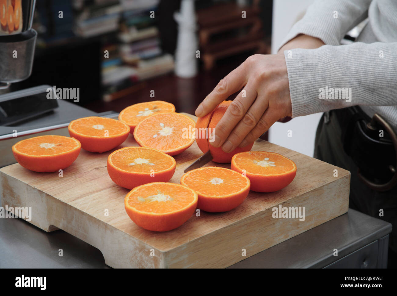 Woman cutting oranges in half Stock Photo - Alamy