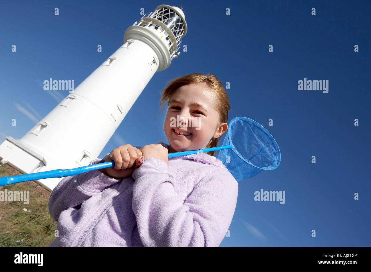 Nine year old girl with fishing net at Flamborough lighthouse East ...