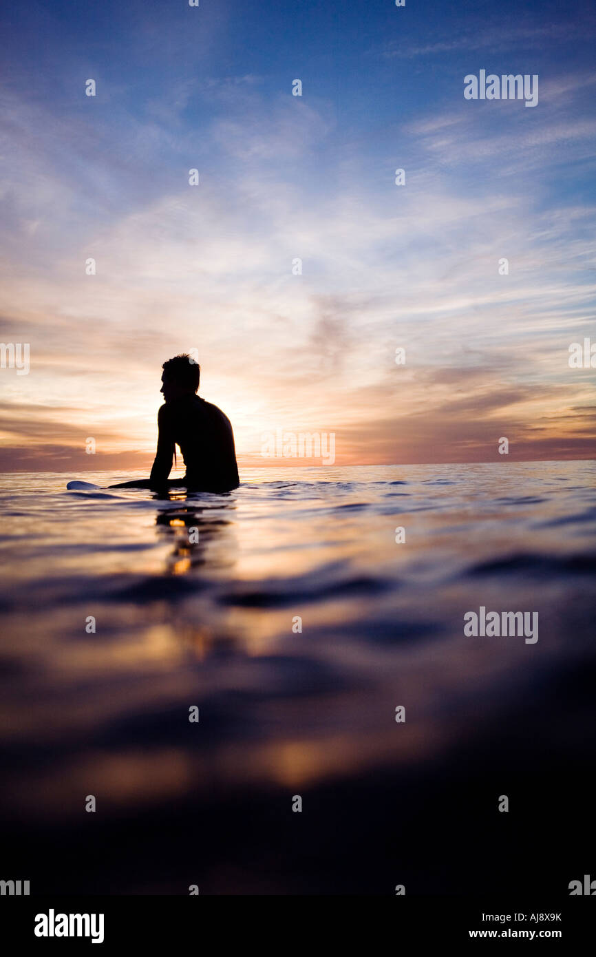 A lone surfer in the sunset Stock Photo - Alamy