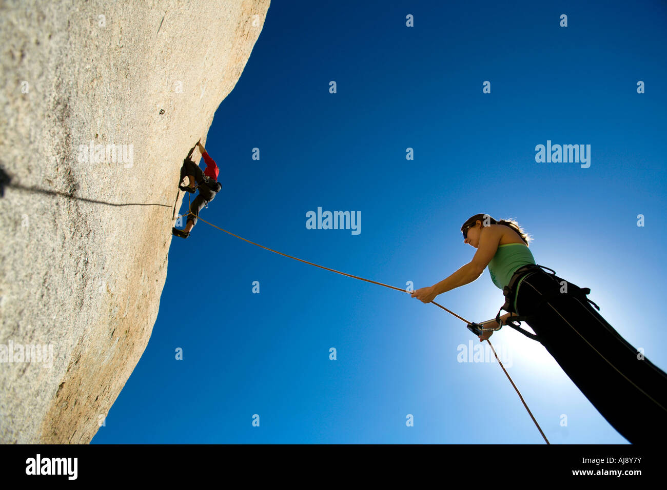 Female belaying against blue sky Stock Photo - Alamy