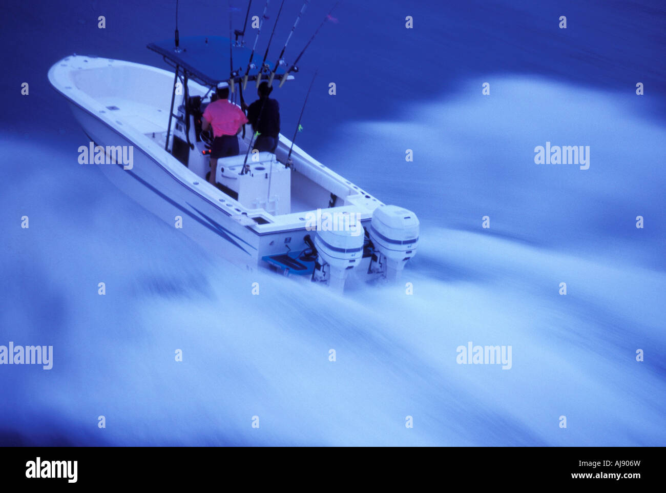 Men speed across open water in a boat Stock Photo - Alamy