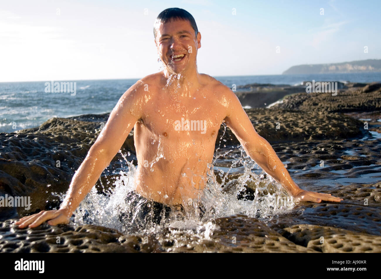 Man bathes in coastal waterhole Stock Photo - Alamy