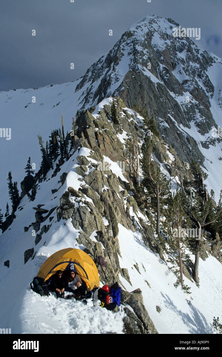 Two women camping below mountain Stock Photo - Alamy