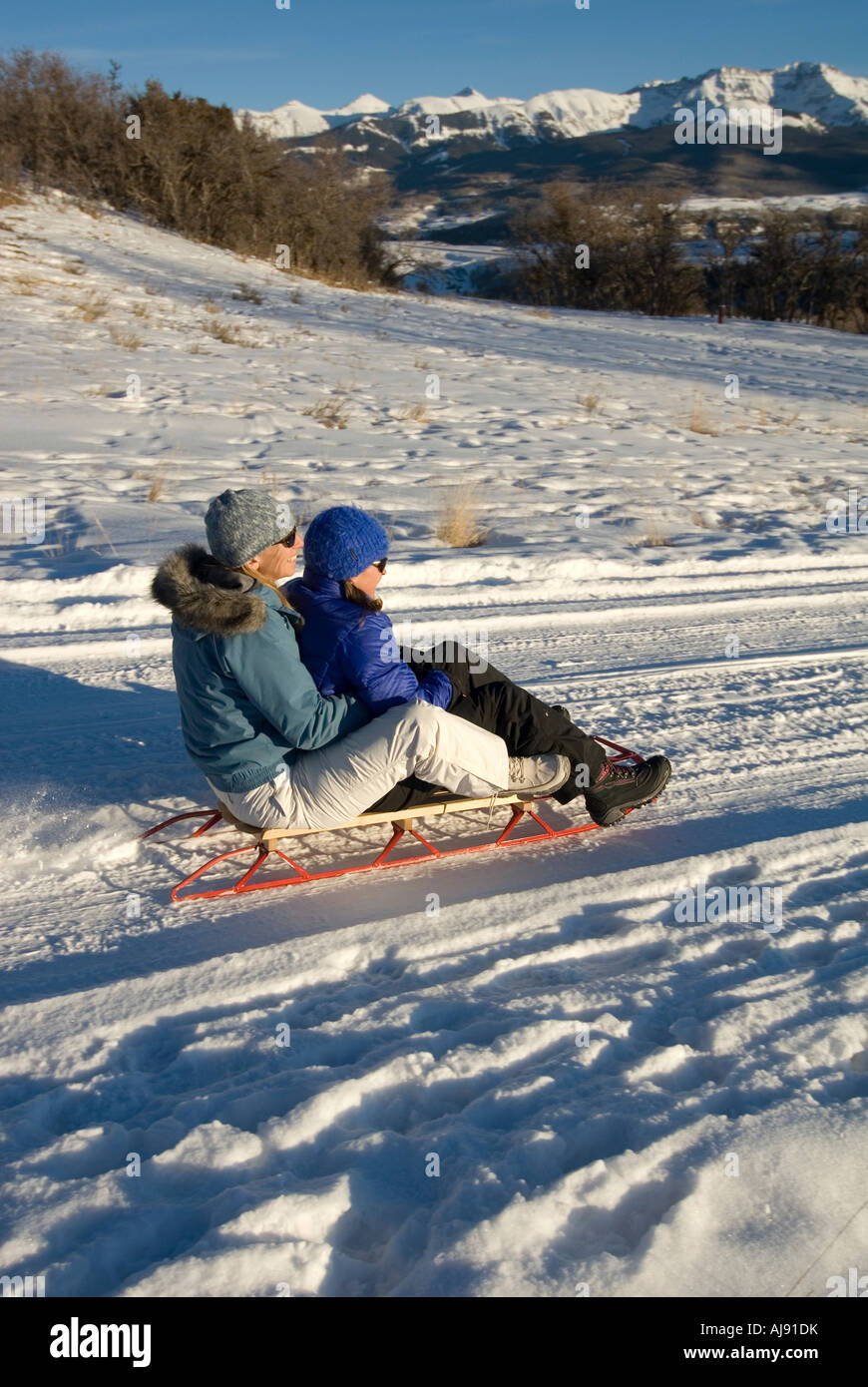 Two women riding a sled Stock Photo - Alamy