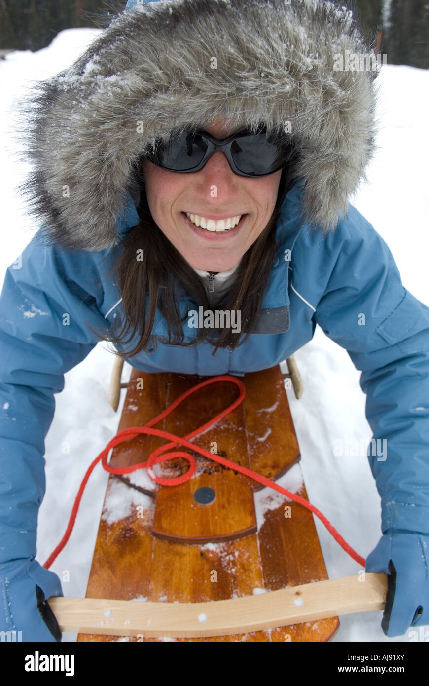 Woman smiling on sled Stock Photo - Alamy