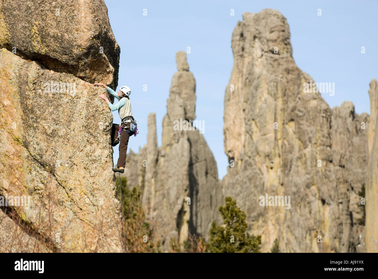Woman climbing rock spire Stock Photo - Alamy