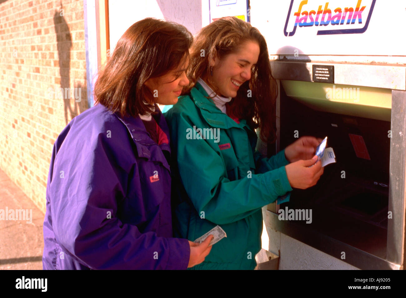 Tongan American sisters age 15 and 17 using outdoor cash machine. St ...