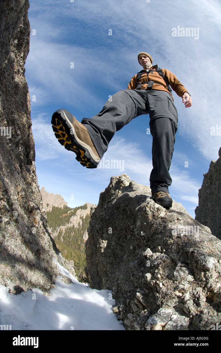Man stepping across rock crevasse Stock Photo - Alamy