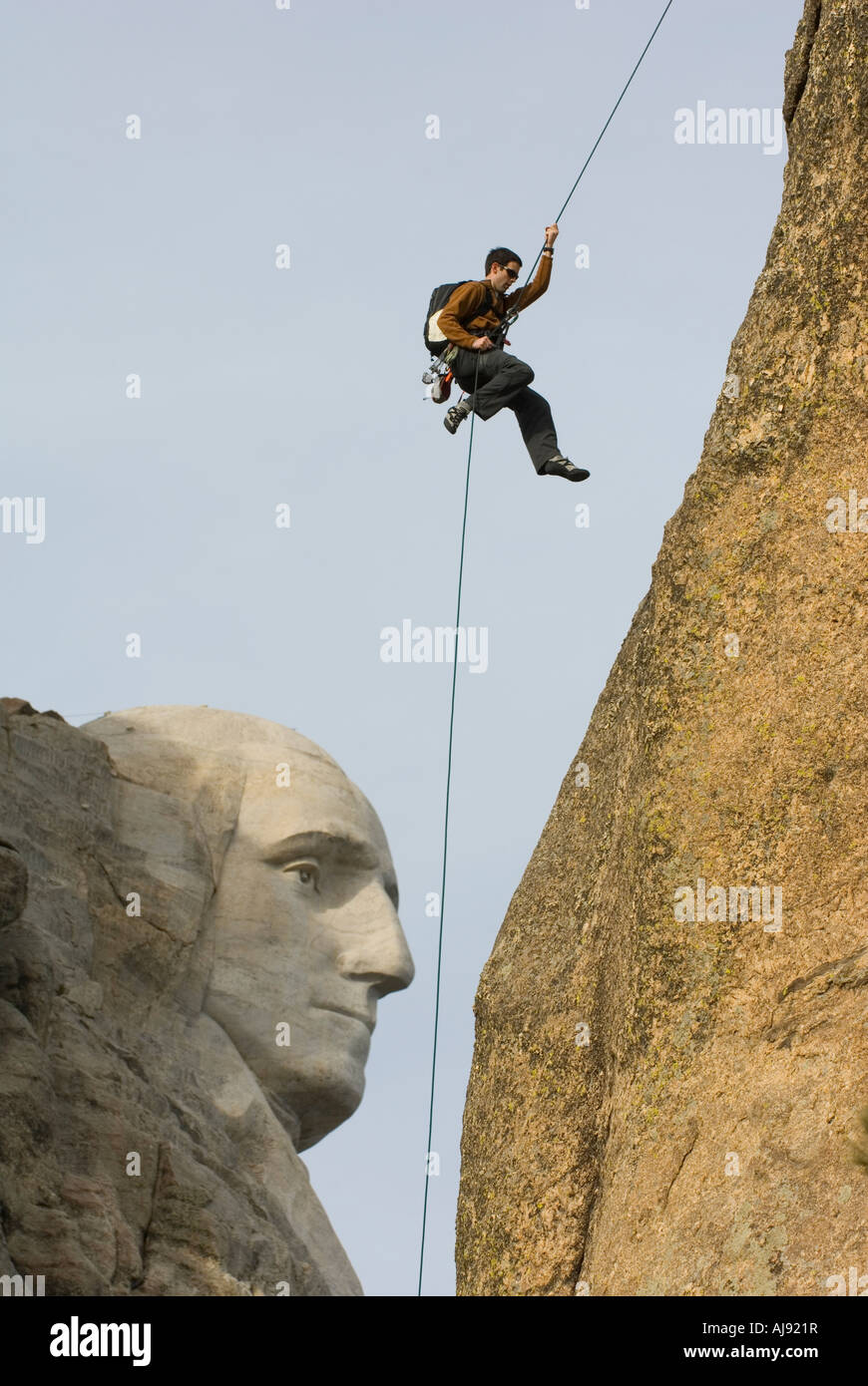 Man rappelling rock face Stock Photo - Alamy