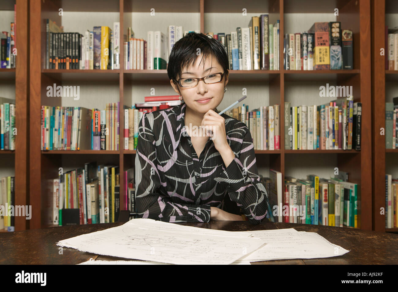 Young woman studying in library Stock Photo - Alamy