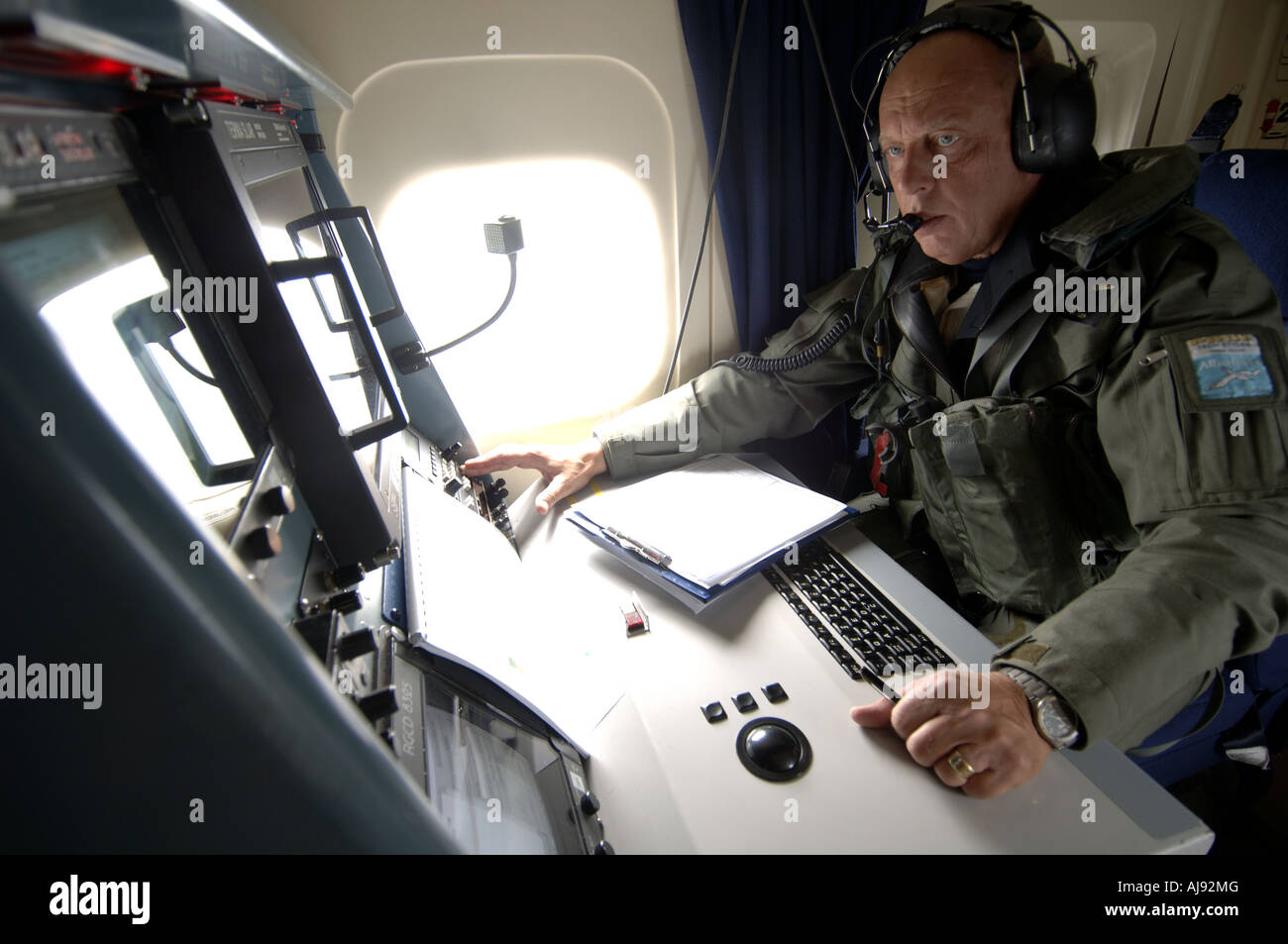 A member of the Dutch coast guard behind high tech equipment inside a ...