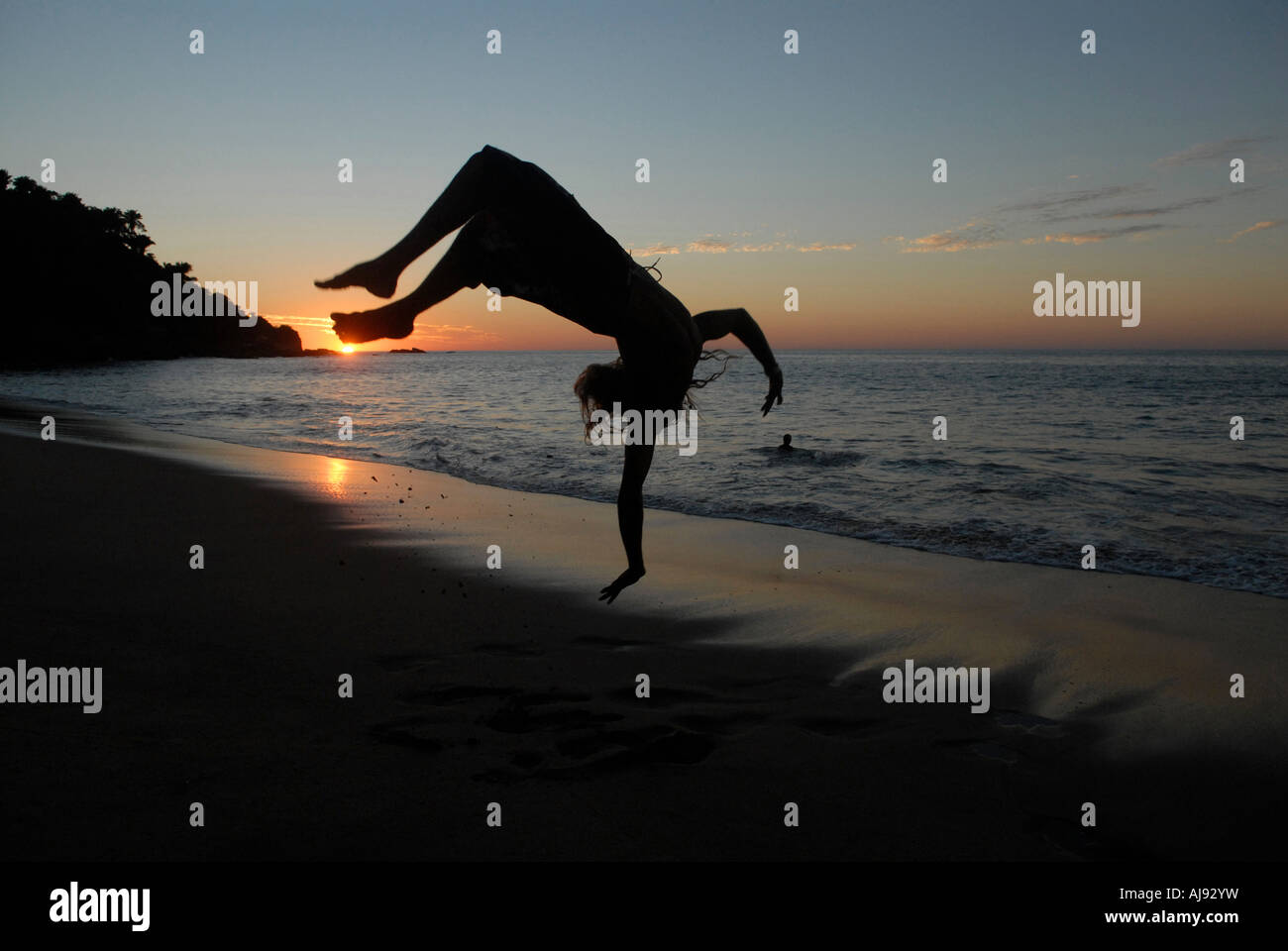 Beach jump, hand spring Stock Photo - Alamy