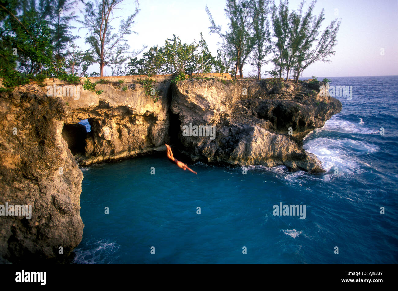 Man diving off cliff Stock Photo - Alamy
