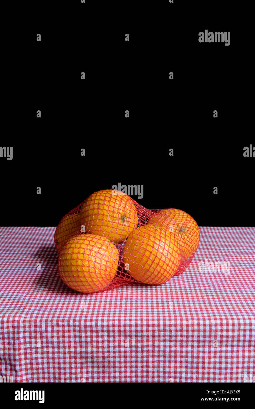 Group of oranges in net on table Stock Photo - Alamy