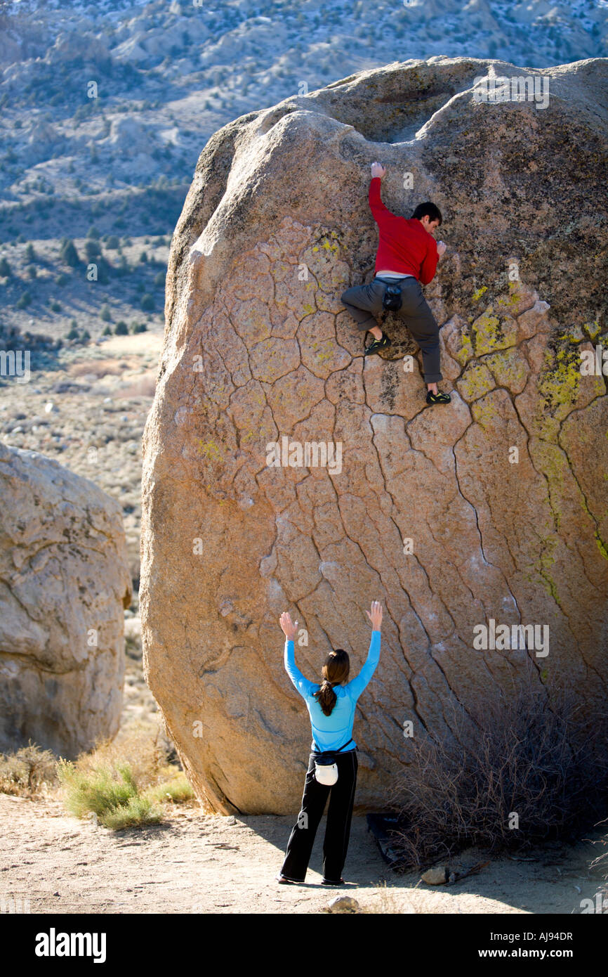 Woman spotting a man on a boulder Stock Photo - Alamy