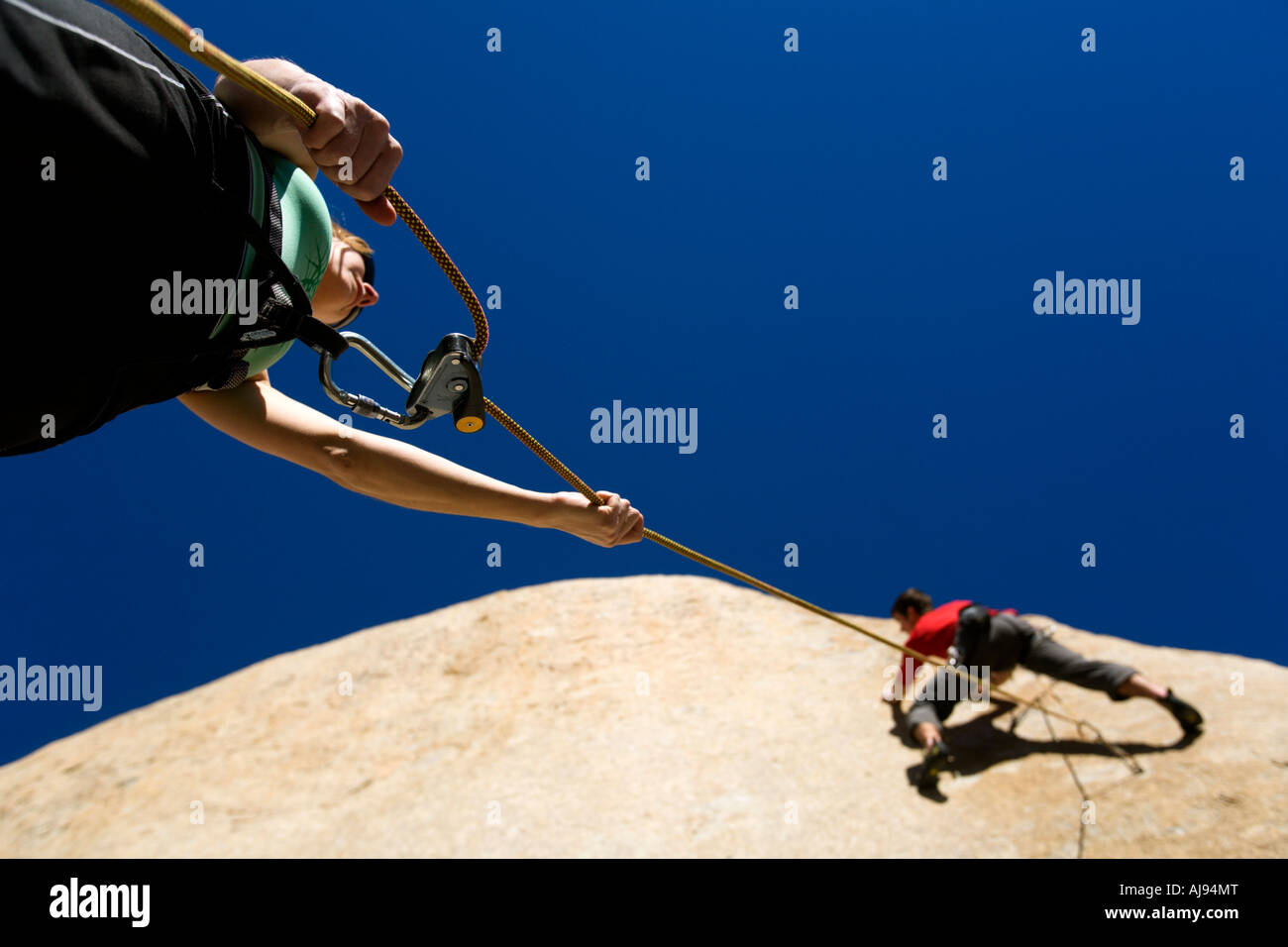 Woman belaying another climber Stock Photo - Alamy